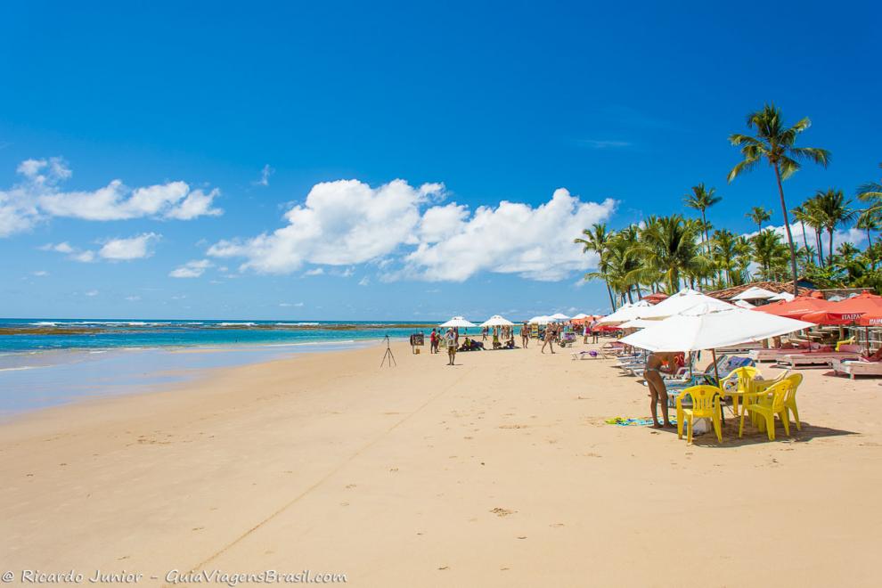 Imagem de casal caminhando na beira da Praia de Taipu de Fora.
